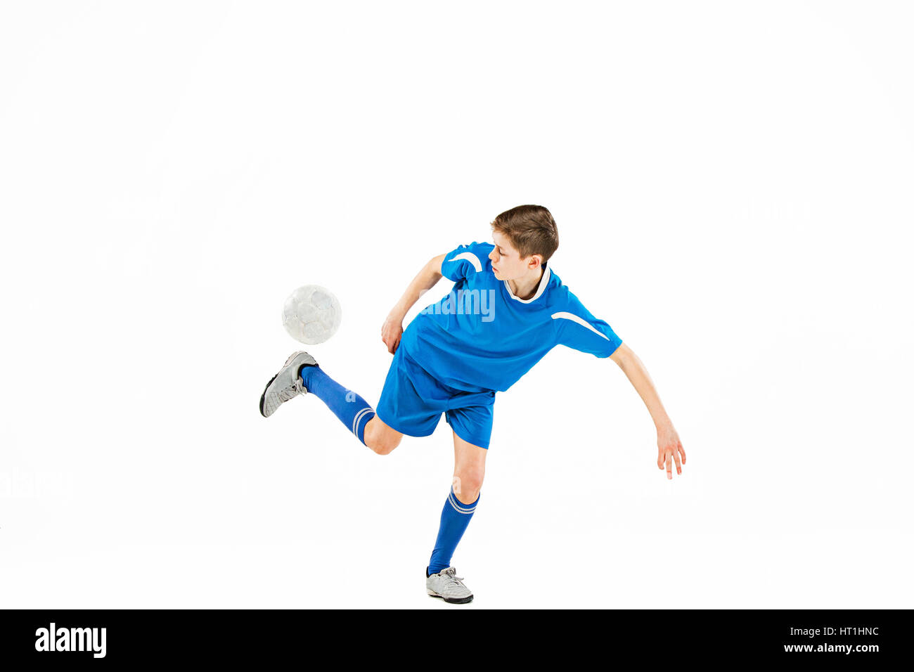 Young boy with soccer ball doing flying kick, isolated on white Stock ...
