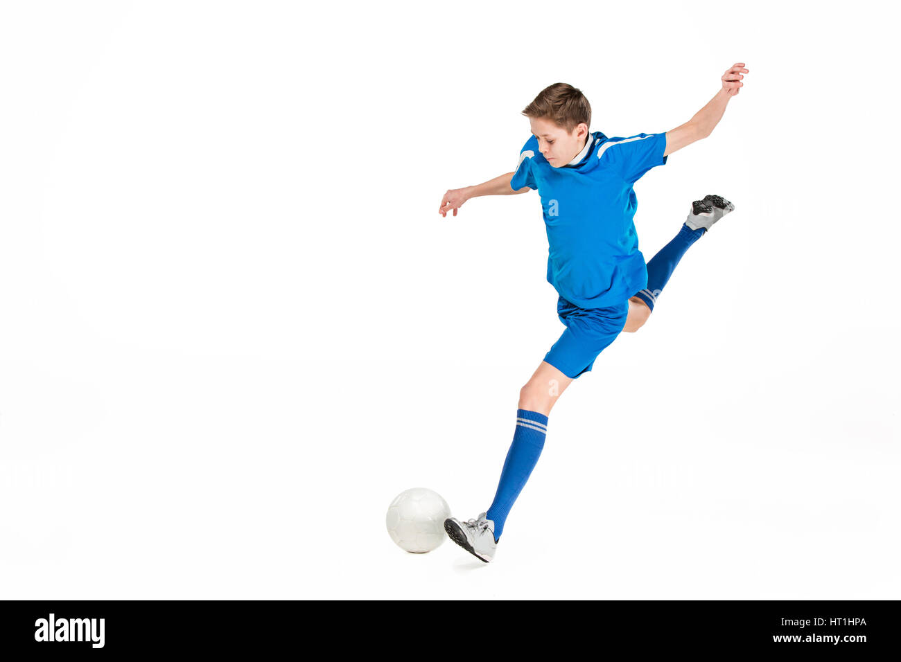 Young boy with soccer ball doing flying kick, isolated on white Stock ...