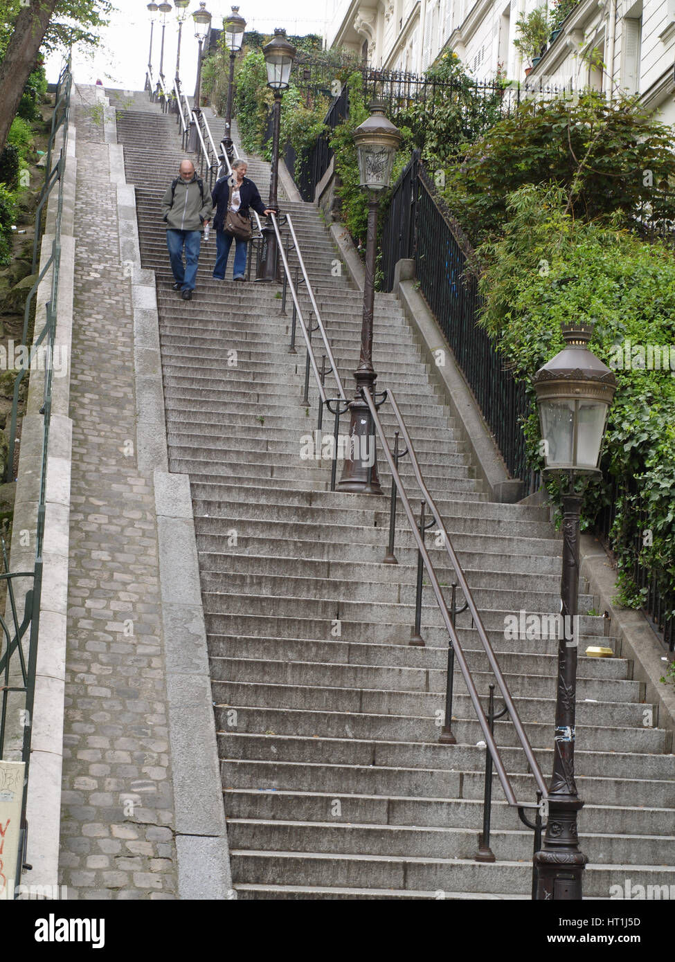 Two people on steps Basilica of the Sacred Heart of Paris, commonly ...