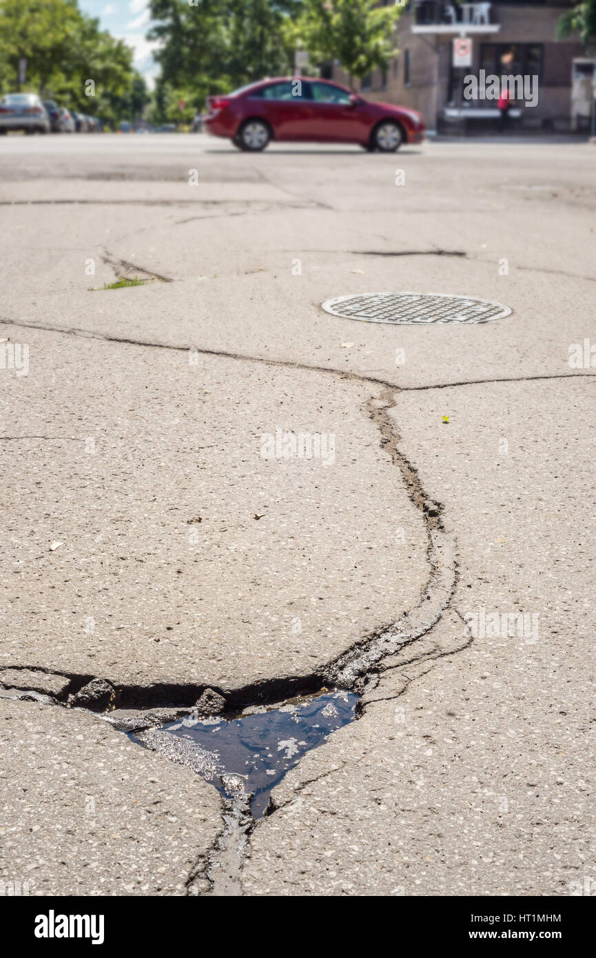 Large deep pothole with traffic in the background in Montreal street ...