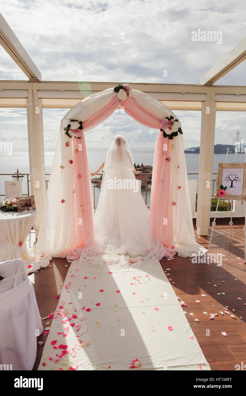 bride in wedding arch destination. Beautiful wedding arch and isle ...