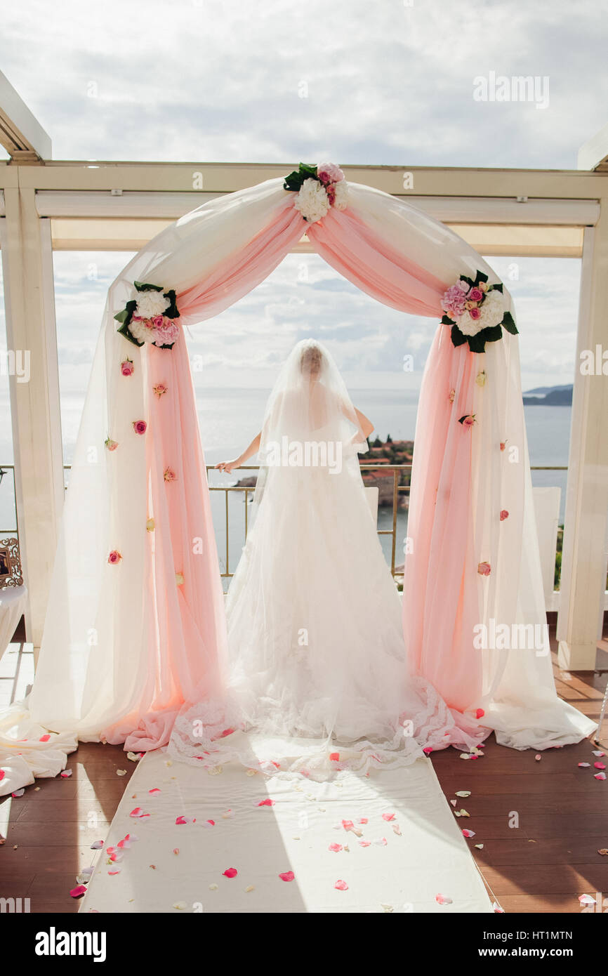 bride in wedding arch destination. Beautiful wedding arch and isle ...