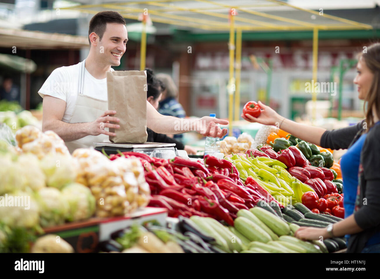 woman choosing fresh vegetables for measuring in grocery store Stock ...