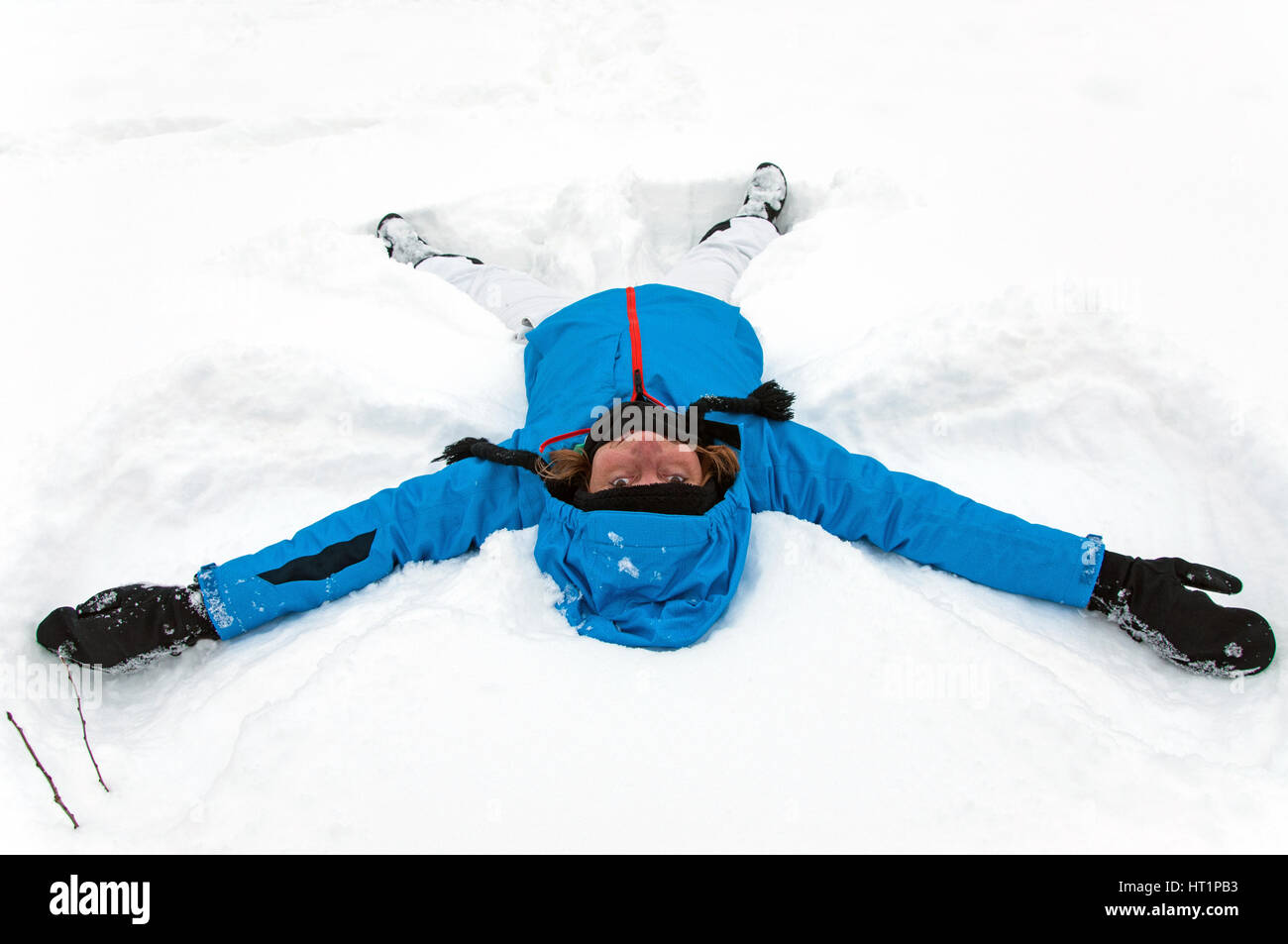 Beautiful girl making a winter snow angel Stock Photo - Alamy