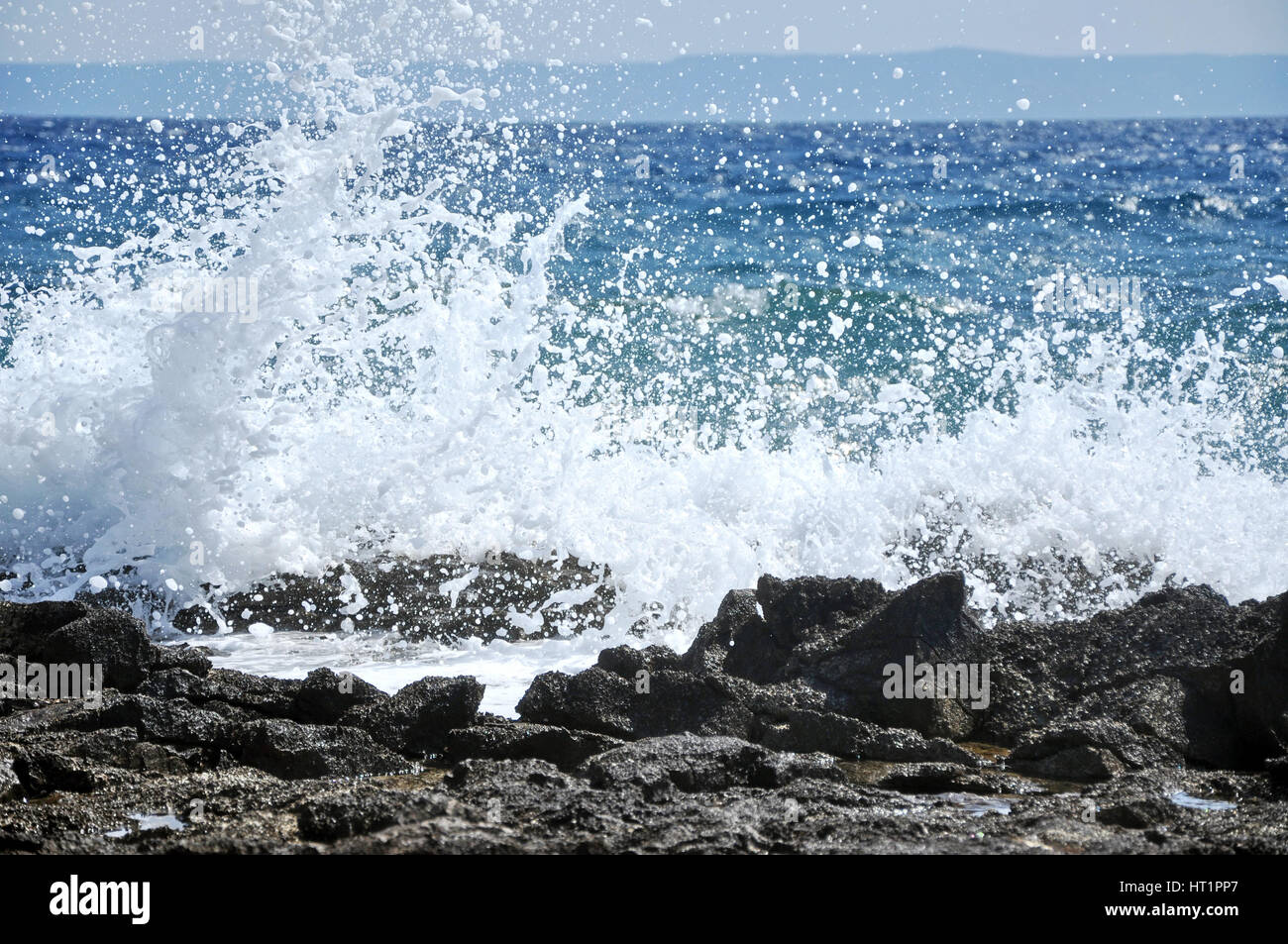 Splashing sea wave in a rocky beach Stock Photo - Alamy