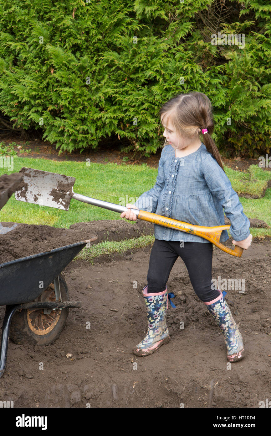 young girl with spade digging wildlife pond in garden Stock Photo - Alamy