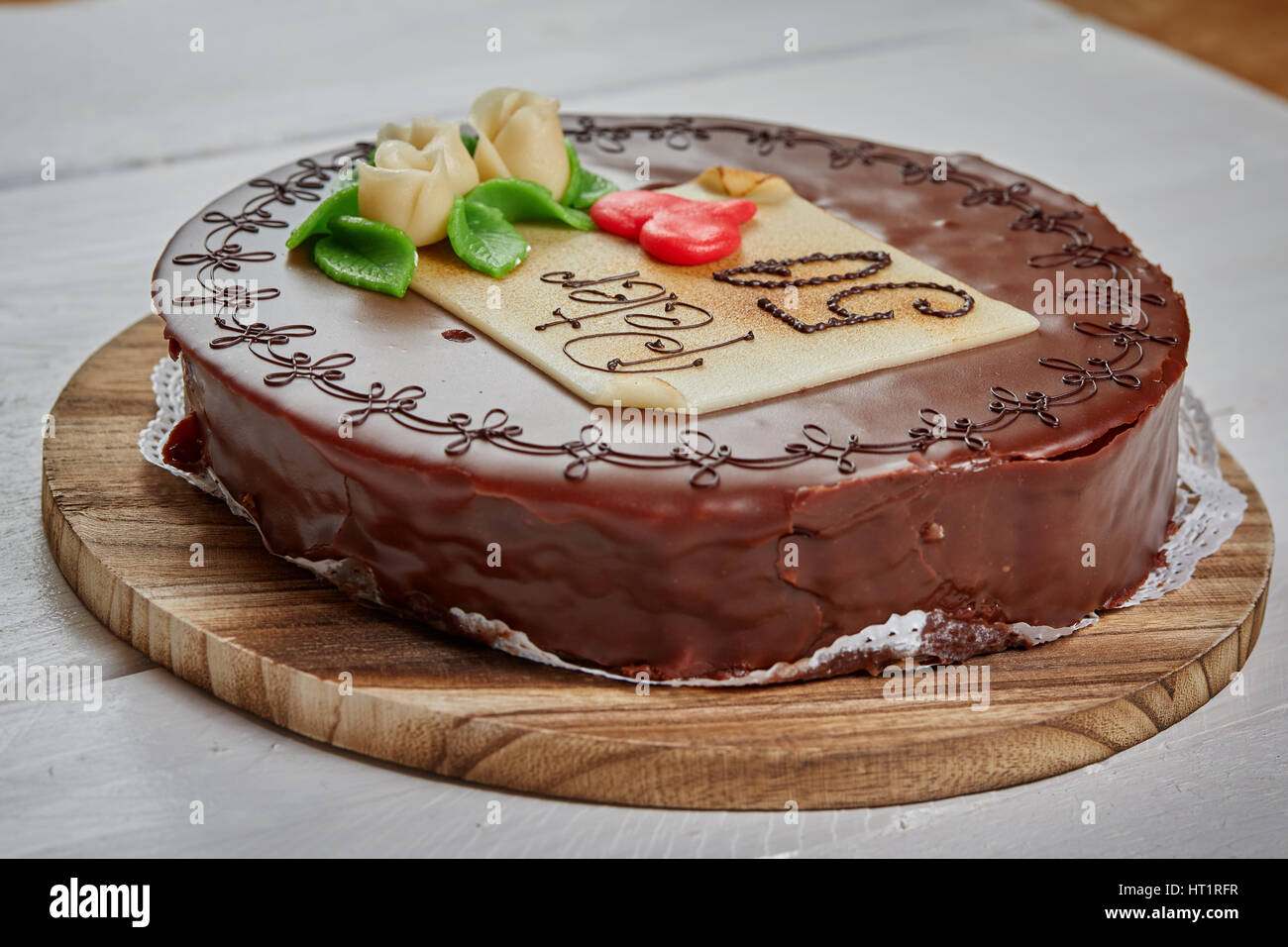 Birthday Sacher cake with chocolate and marzipan on white wooden table ...
