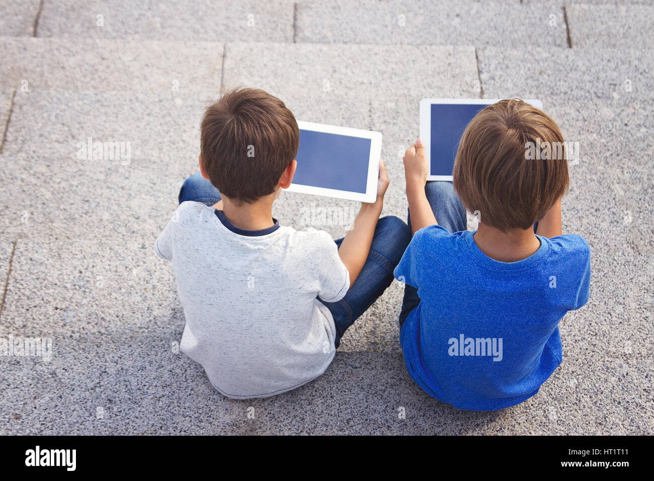 Children sitting with tablets computers. Back view. Education, learning ...