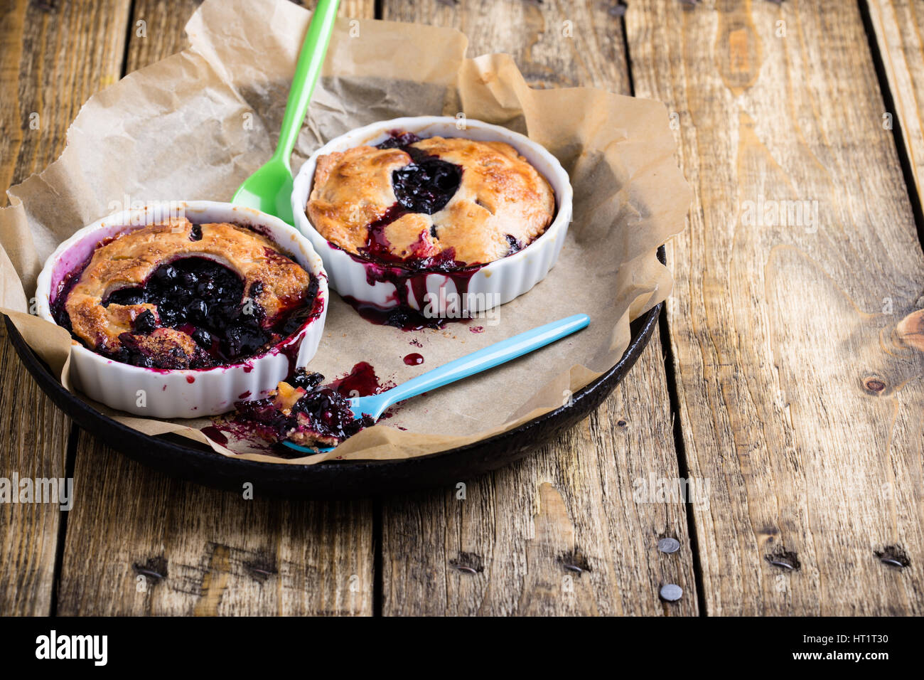 Rustic homemade blueberry mini pie in small ceramic bowls on wooden ...