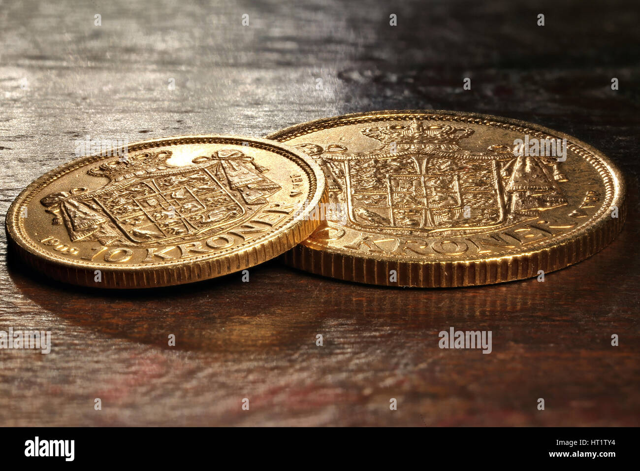Danish gold coins on rustic wooden background Stock Photo - Alamy
