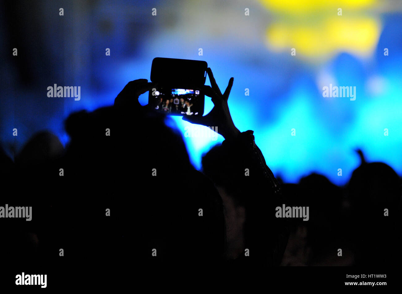 Crowd of partying people taking photos with smartphone at Electric ...