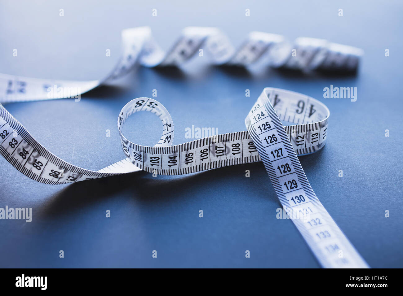 Swirling tape measure on dark background Stock Photo - Alamy