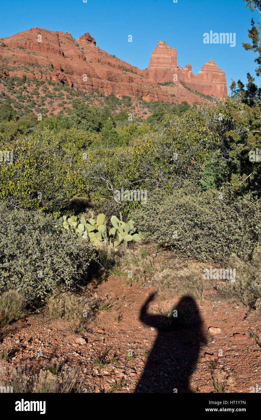 Shadow of a woman traveler waving in Sedona, Arizona, on a trail off ...