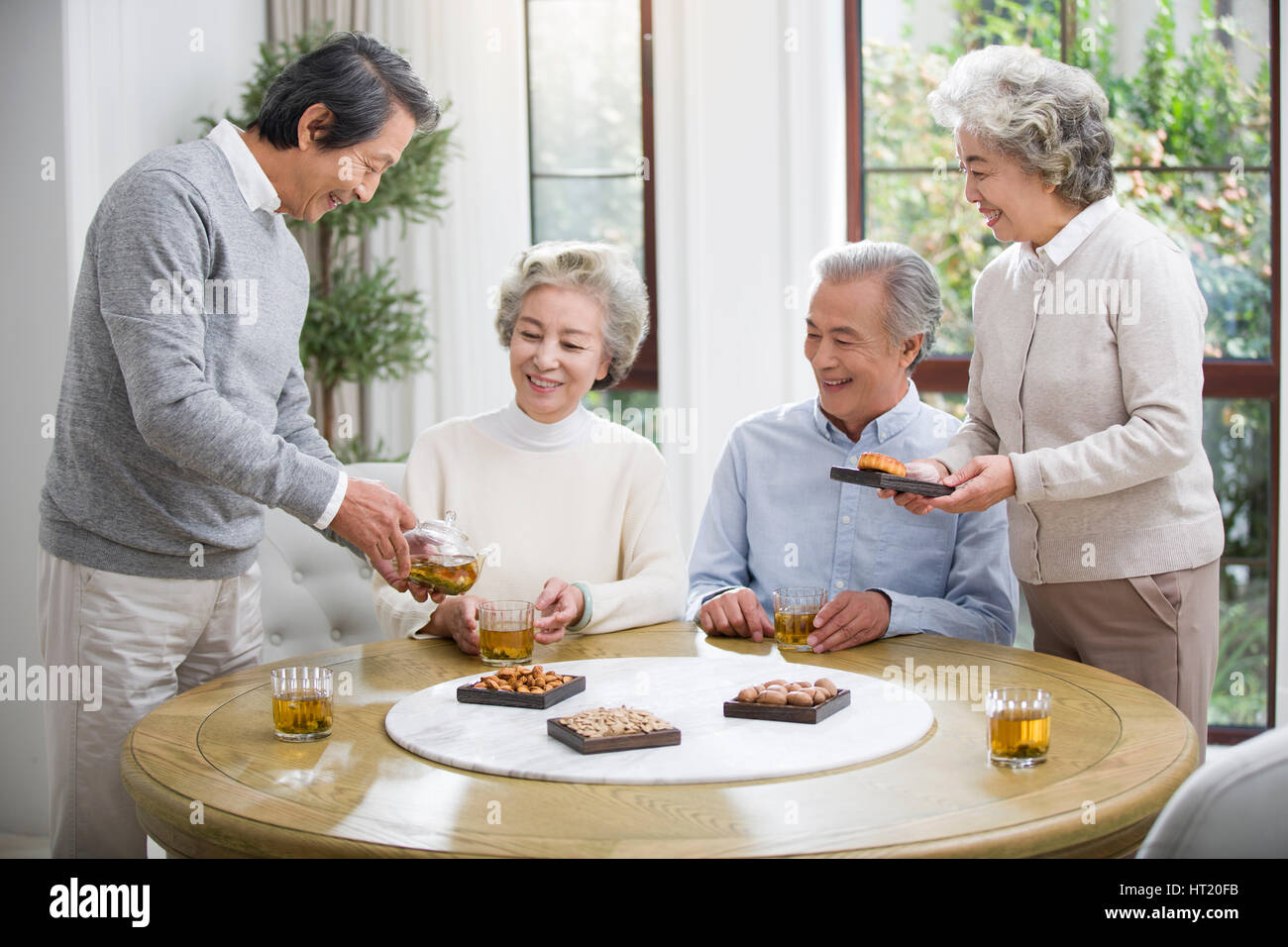 Happy senior friends talking and drinking tea Stock Photo - Alamy