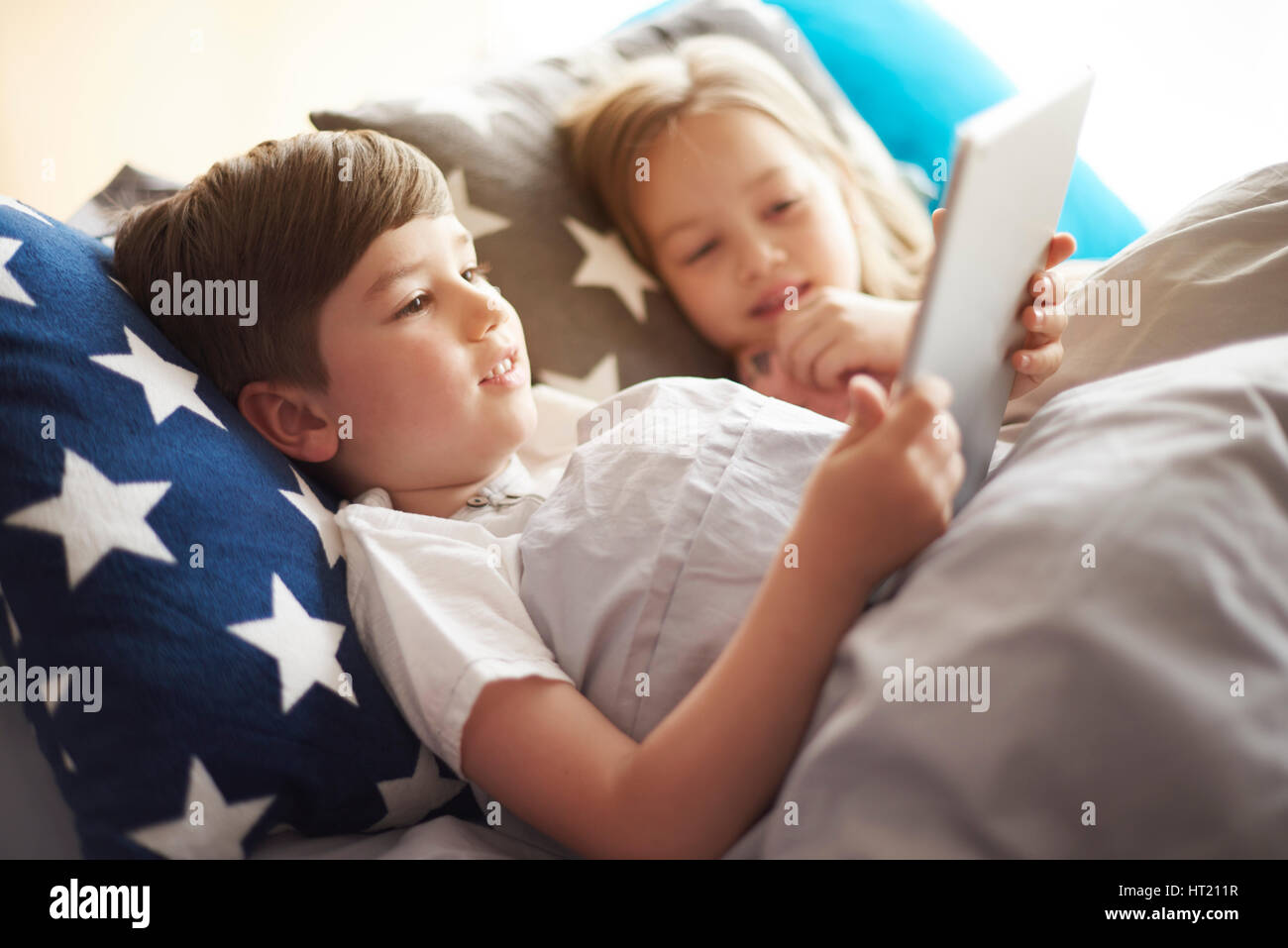 Little kids with digital tablet in bed Stock Photo - Alamy