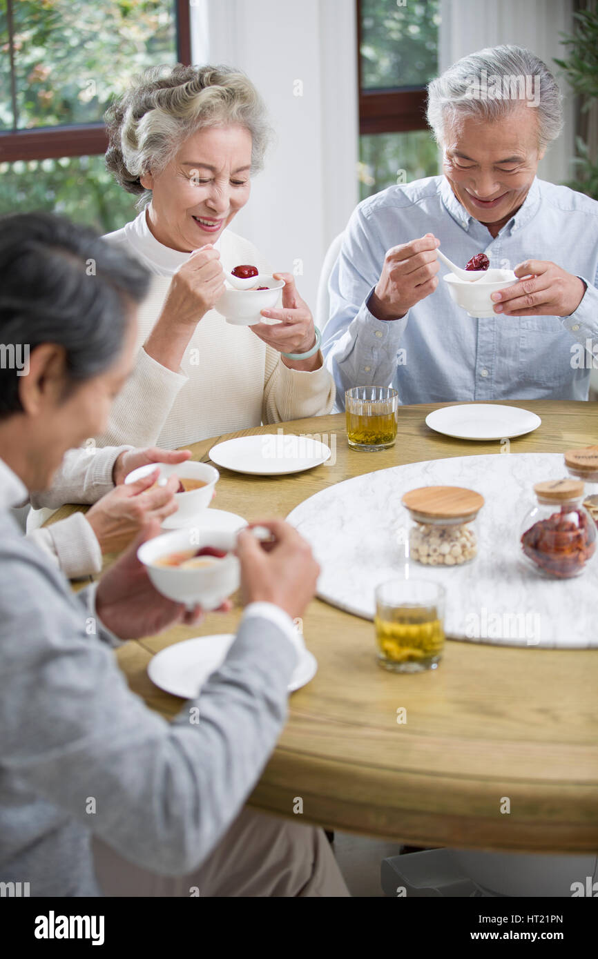 Happy senior friends eating together Stock Photo - Alamy