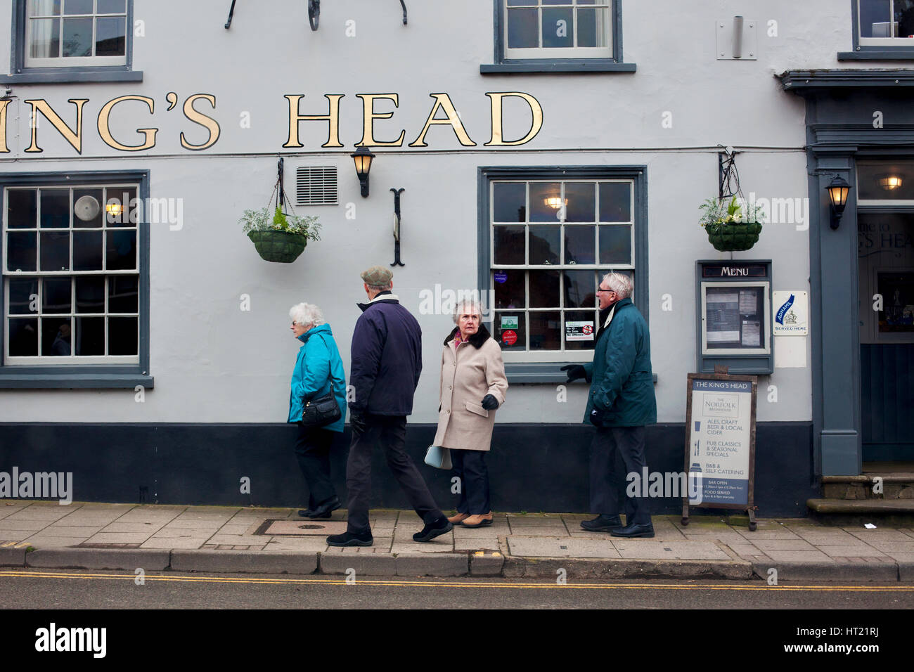 Two old couples walking past the King's Head pub, Holt, Norfolk ...
