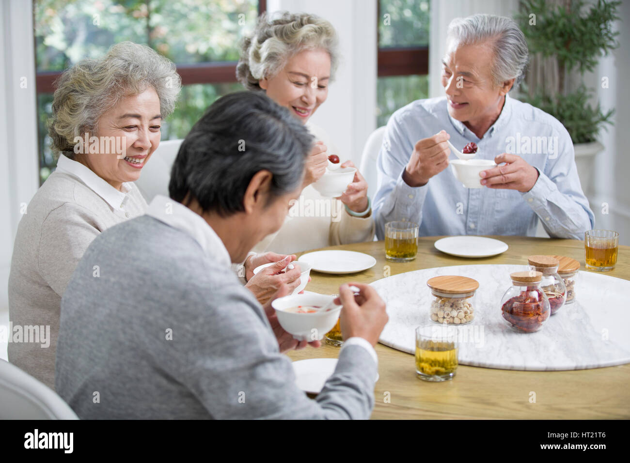 Happy senior friends eating together Stock Photo - Alamy