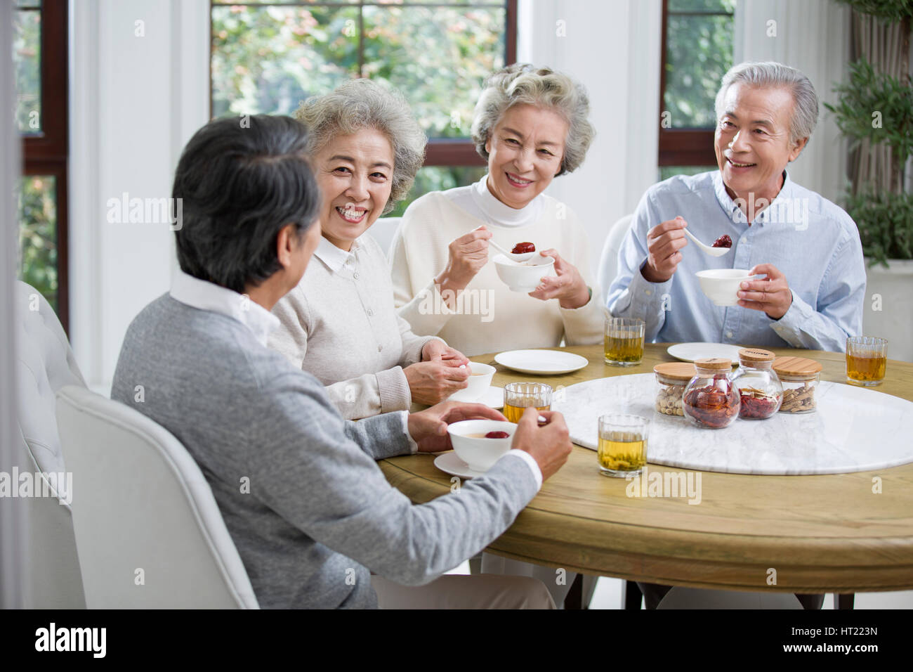 Happy senior friends eating together Stock Photo - Alamy