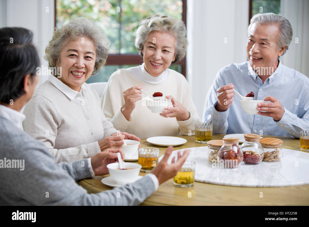 Happy senior friends eating together Stock Photo - Alamy