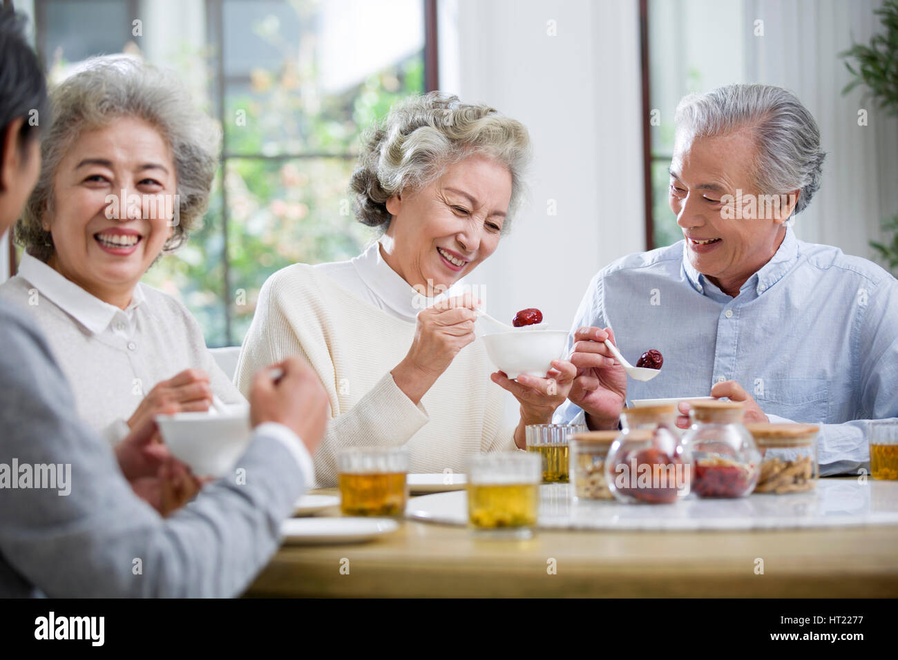 Happy senior friends eating together Stock Photo - Alamy
