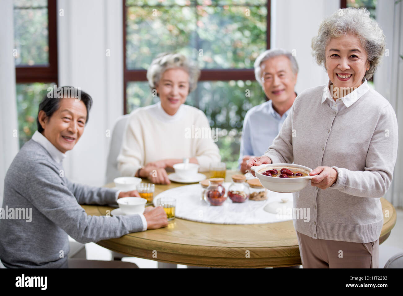 Happy senior friends eating together Stock Photo - Alamy