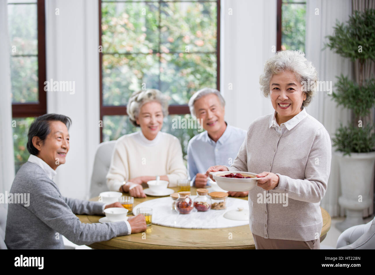 Happy senior friends eating together Stock Photo - Alamy