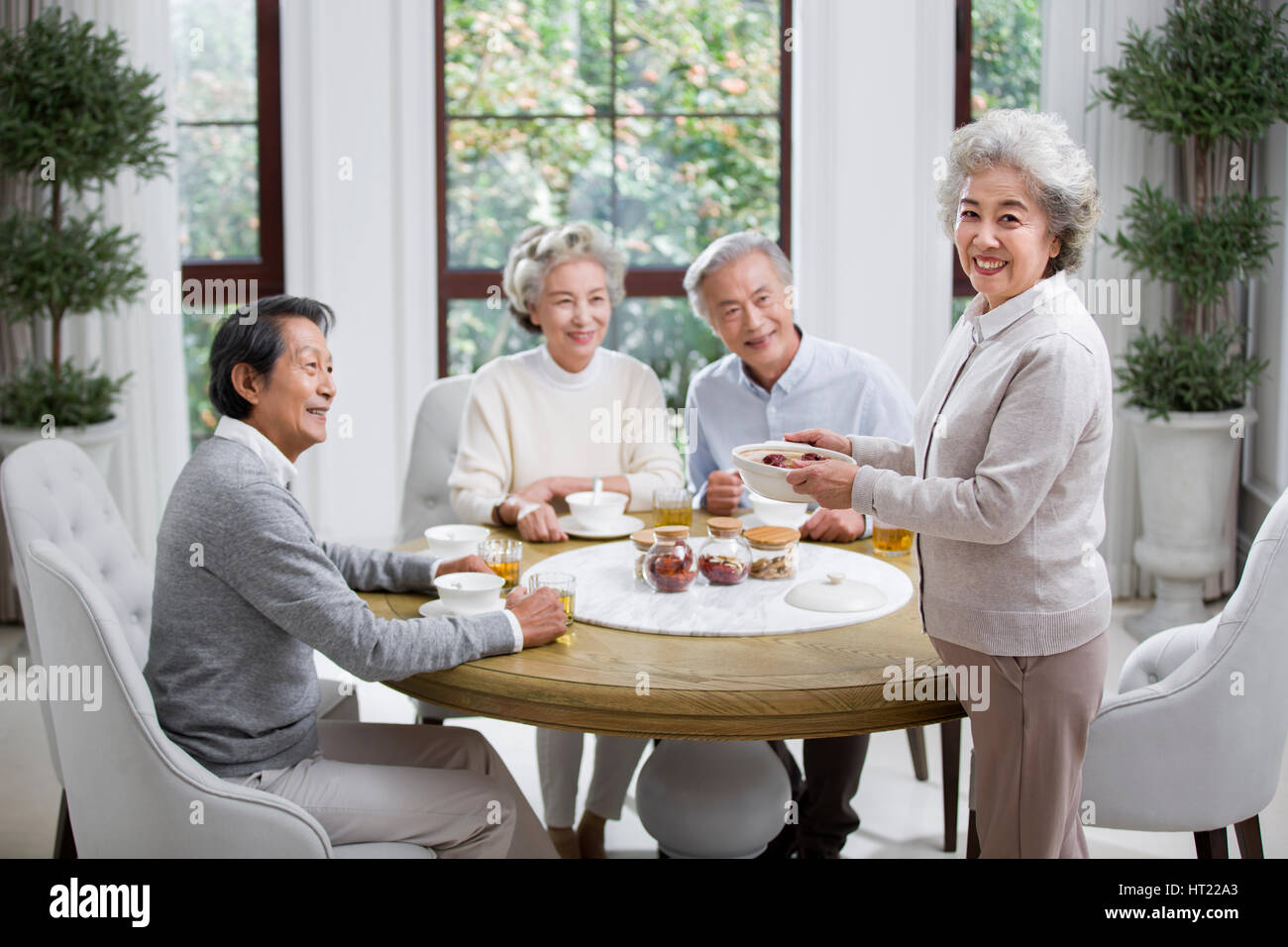 Happy senior friends eating together Stock Photo - Alamy