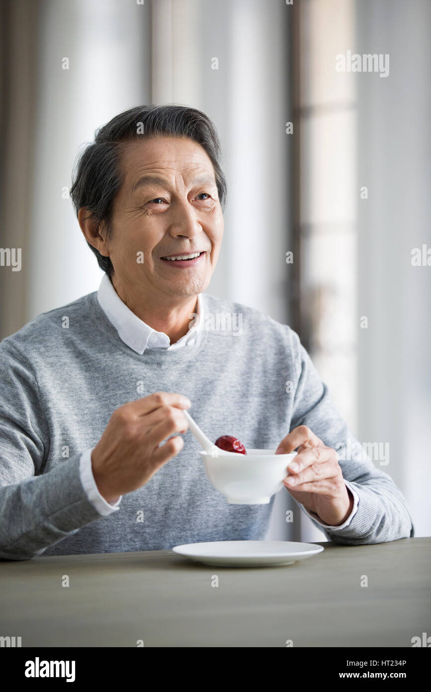 Senior man eating nutritious porridge Stock Photo - Alamy
