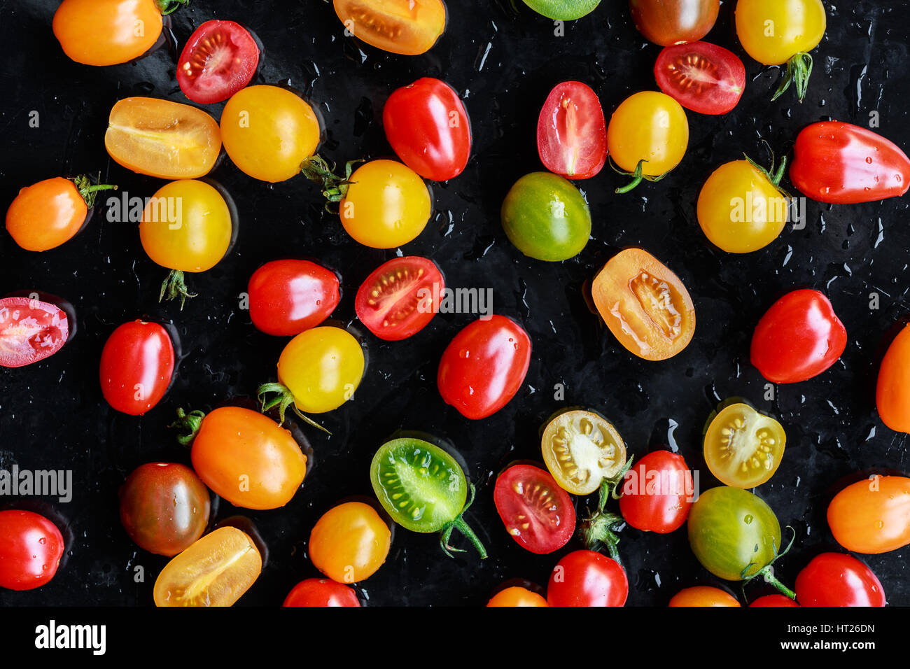 Multi-colored tomatoes on black background Stock Photo - Alamy