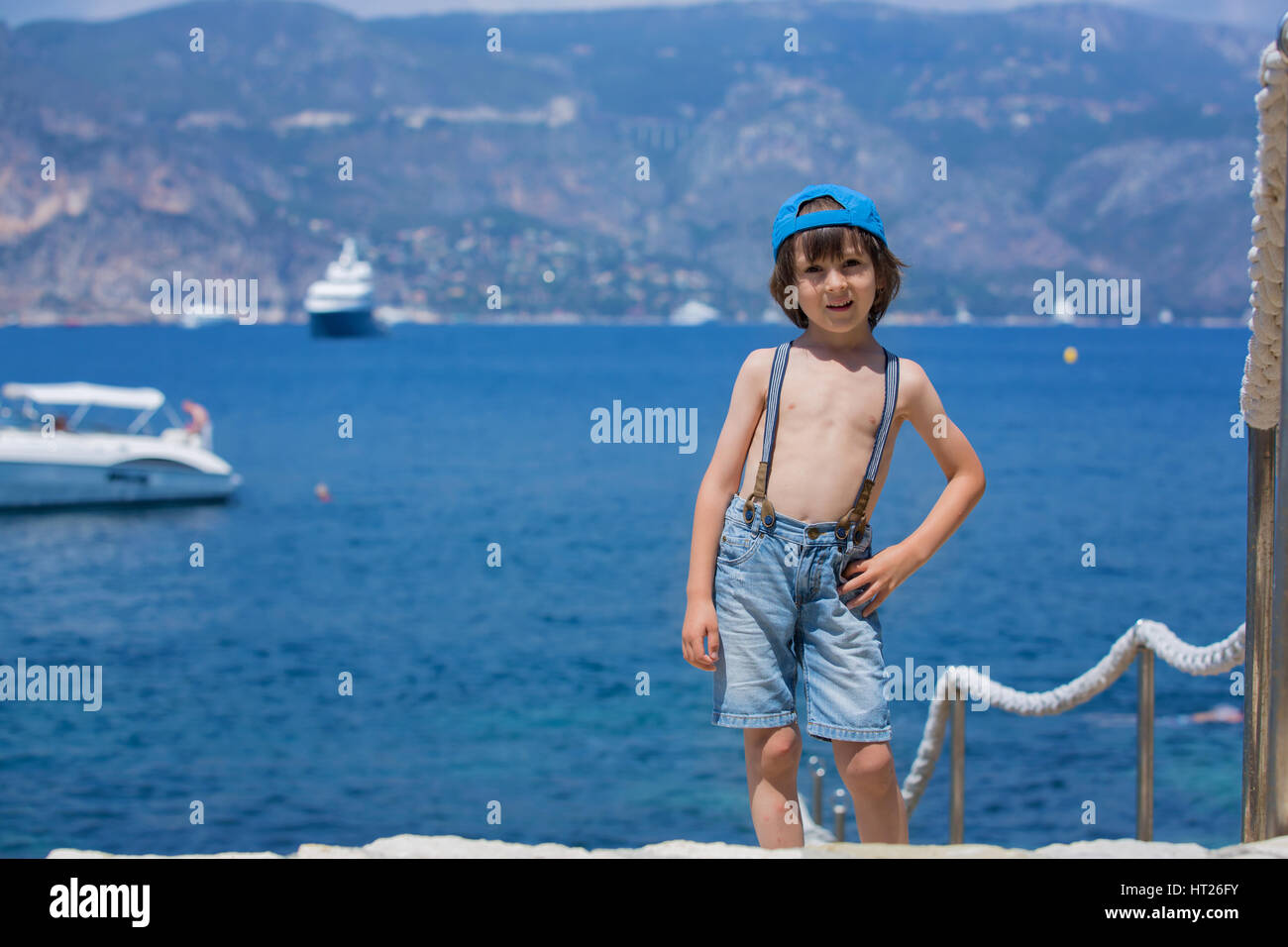 Two children, boy brothers, walking on a path around Mediterranean sea ...