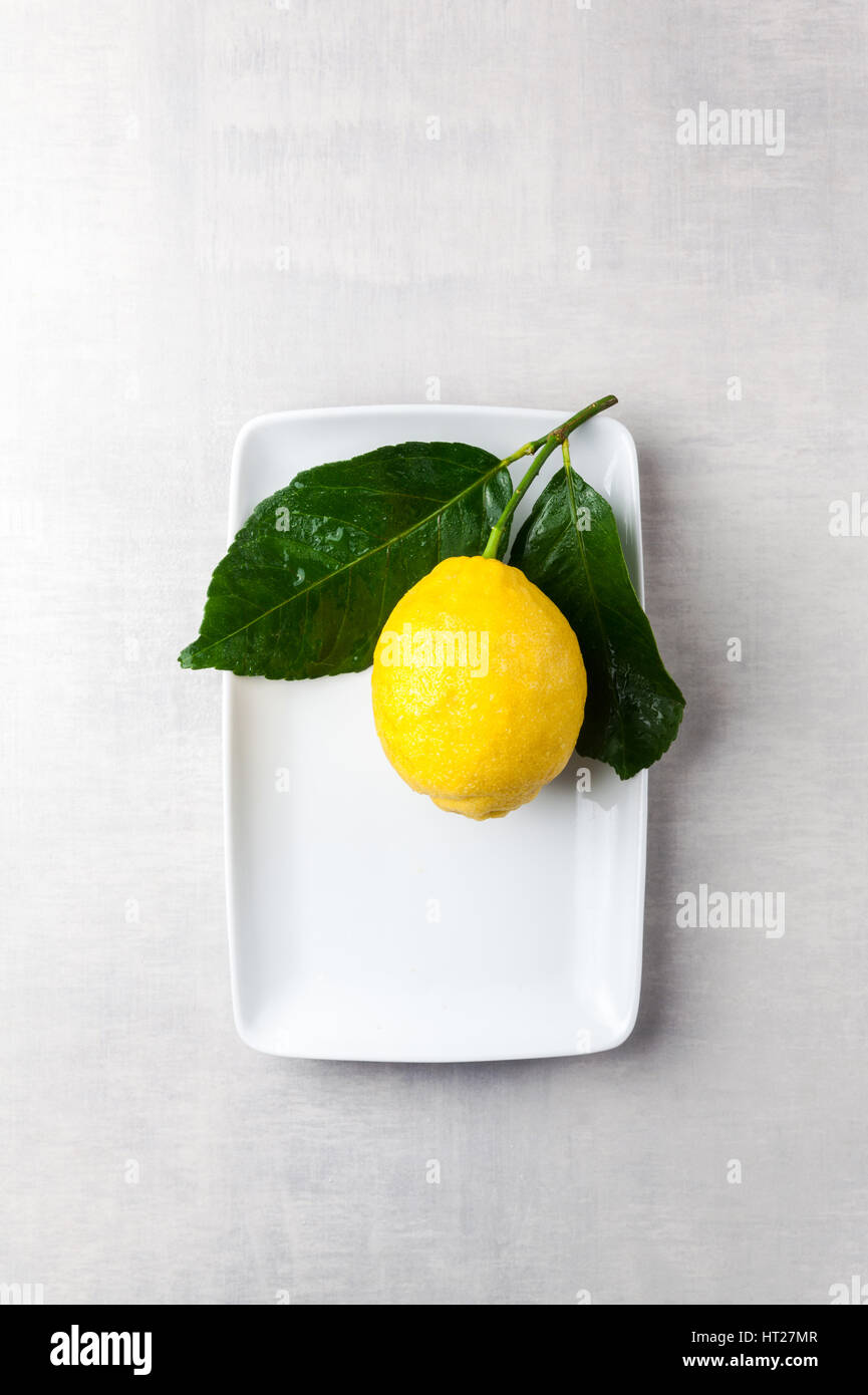 Fresh big natural lemon with leaves on a plate Stock Photo - Alamy