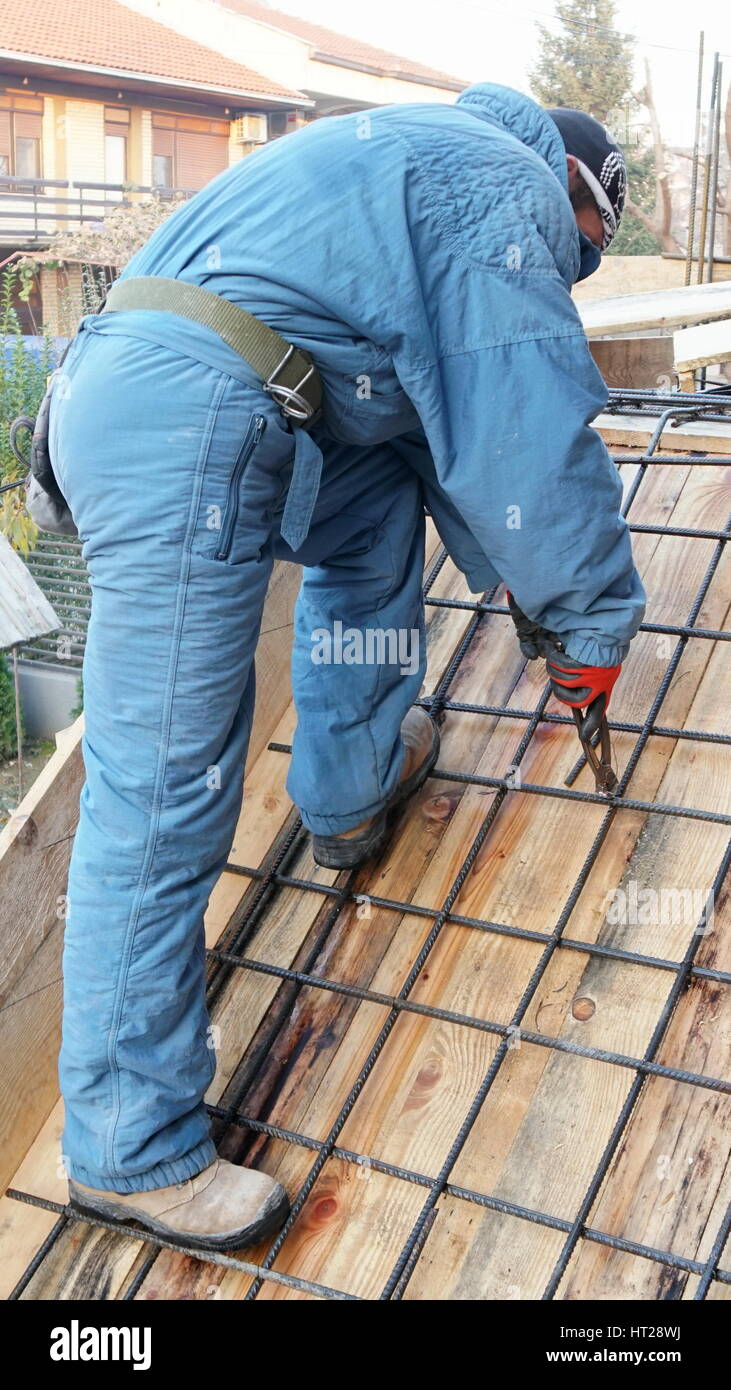 Construction worker working on steel rods used to reinforce concrete ...