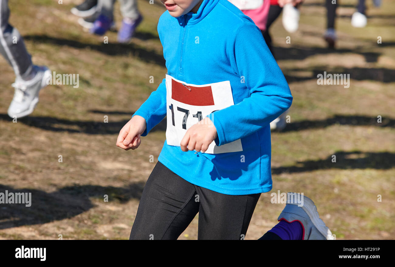 Junior athletic runner on a cross country race. Outdoor circuit ...