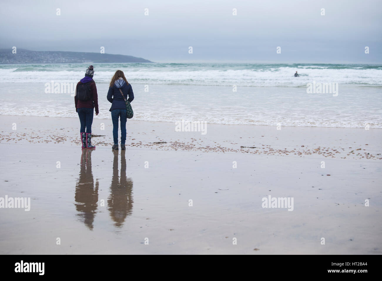 Two Girls Standing on Godrevy Beach, Cornwall UK Stock Photo - Alamy
