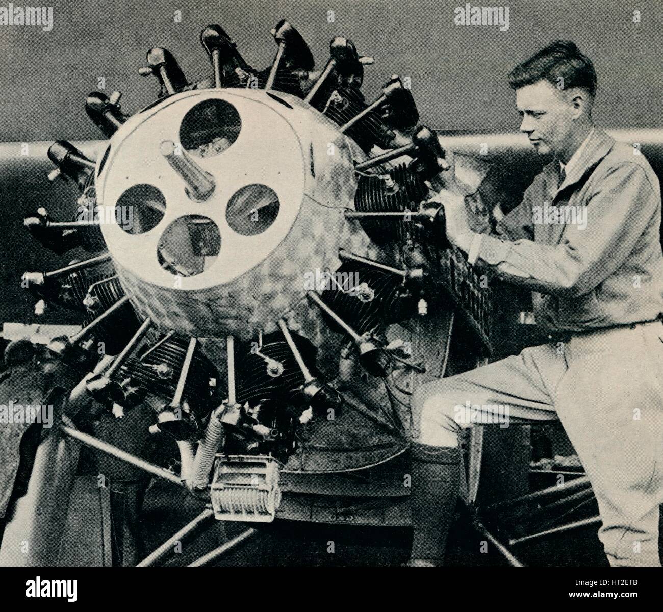 Charles Lindbergh checking the engine of his aircraft before his ...