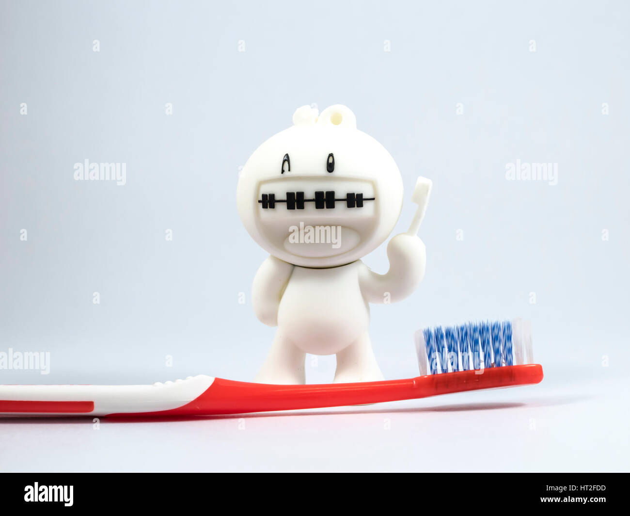 A braces doll and a toothbrush on white background Stock Photo - Alamy