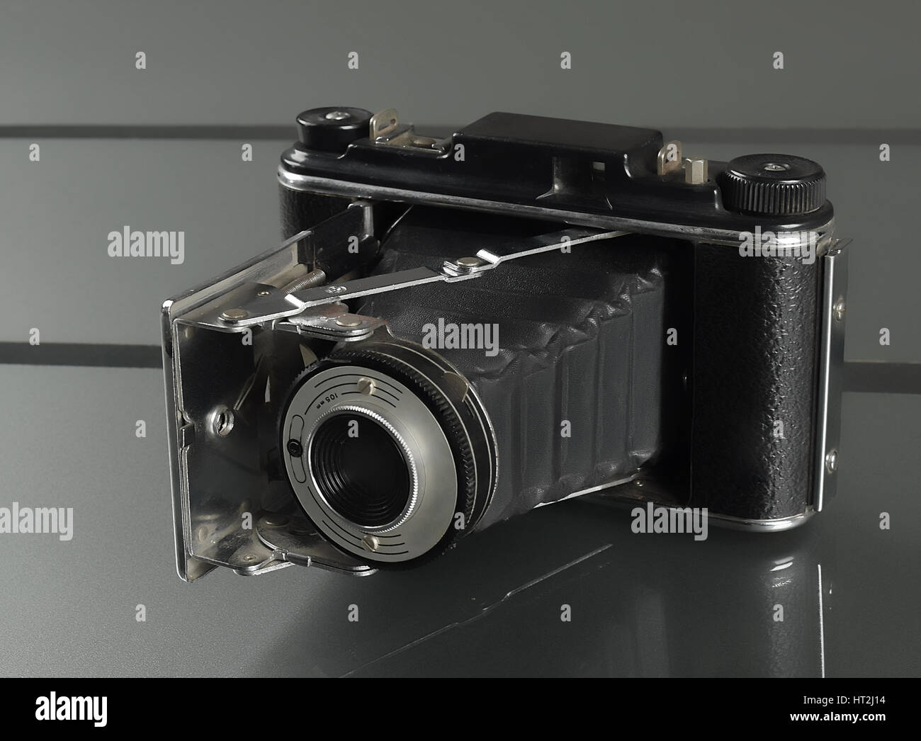 Antique old photo film camera on glass table Stock Photo - Alamy