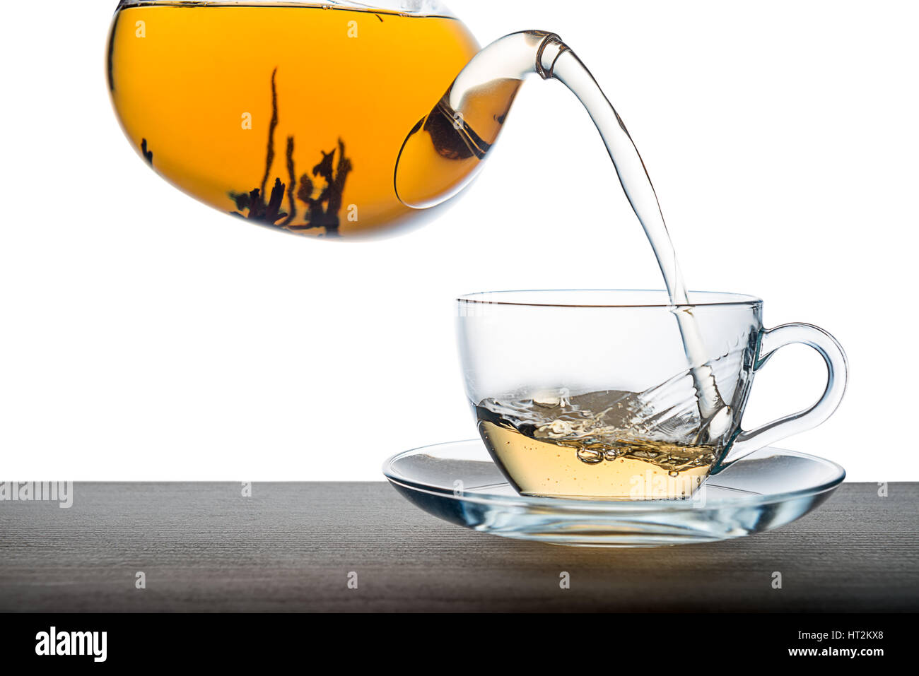 pouring tea from teapot on wooden over white background, close up Stock ...