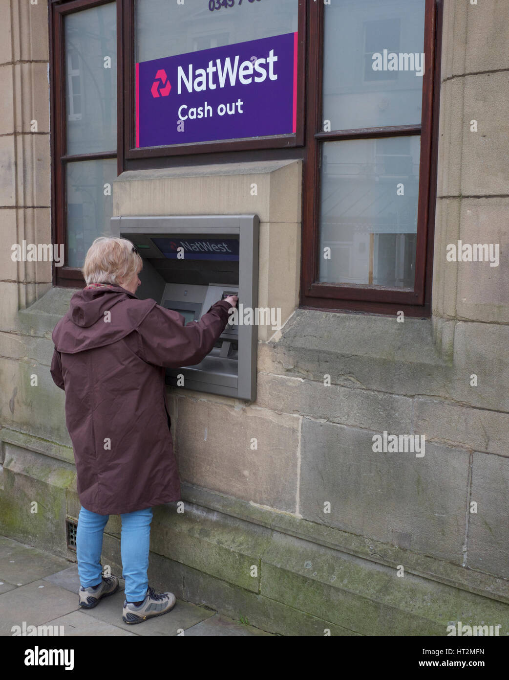 A woman using a service till in Buxton, Derbyshire Stock Photo - Alamy