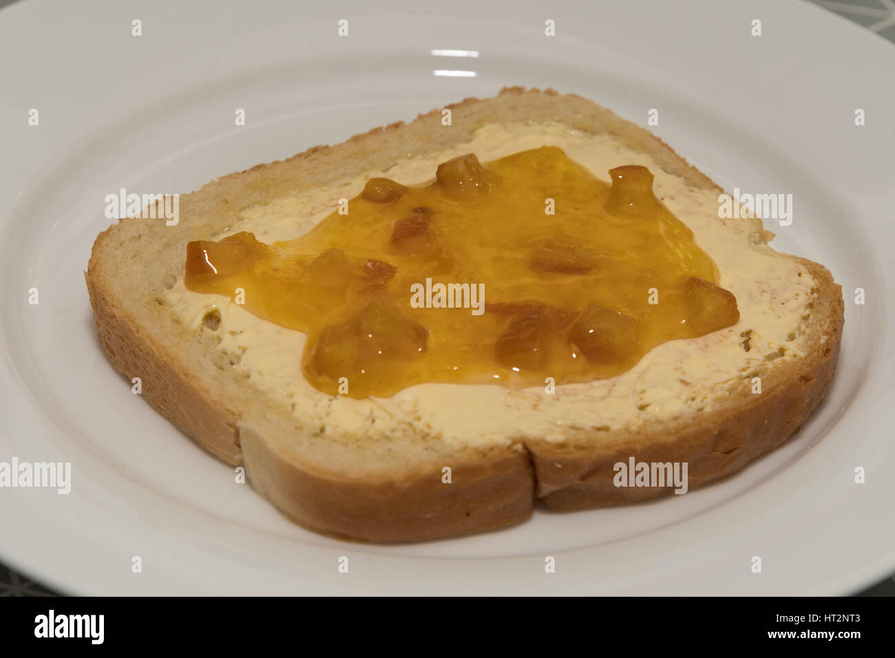 Single toast with orange marmelade topping Stock Photo - Alamy