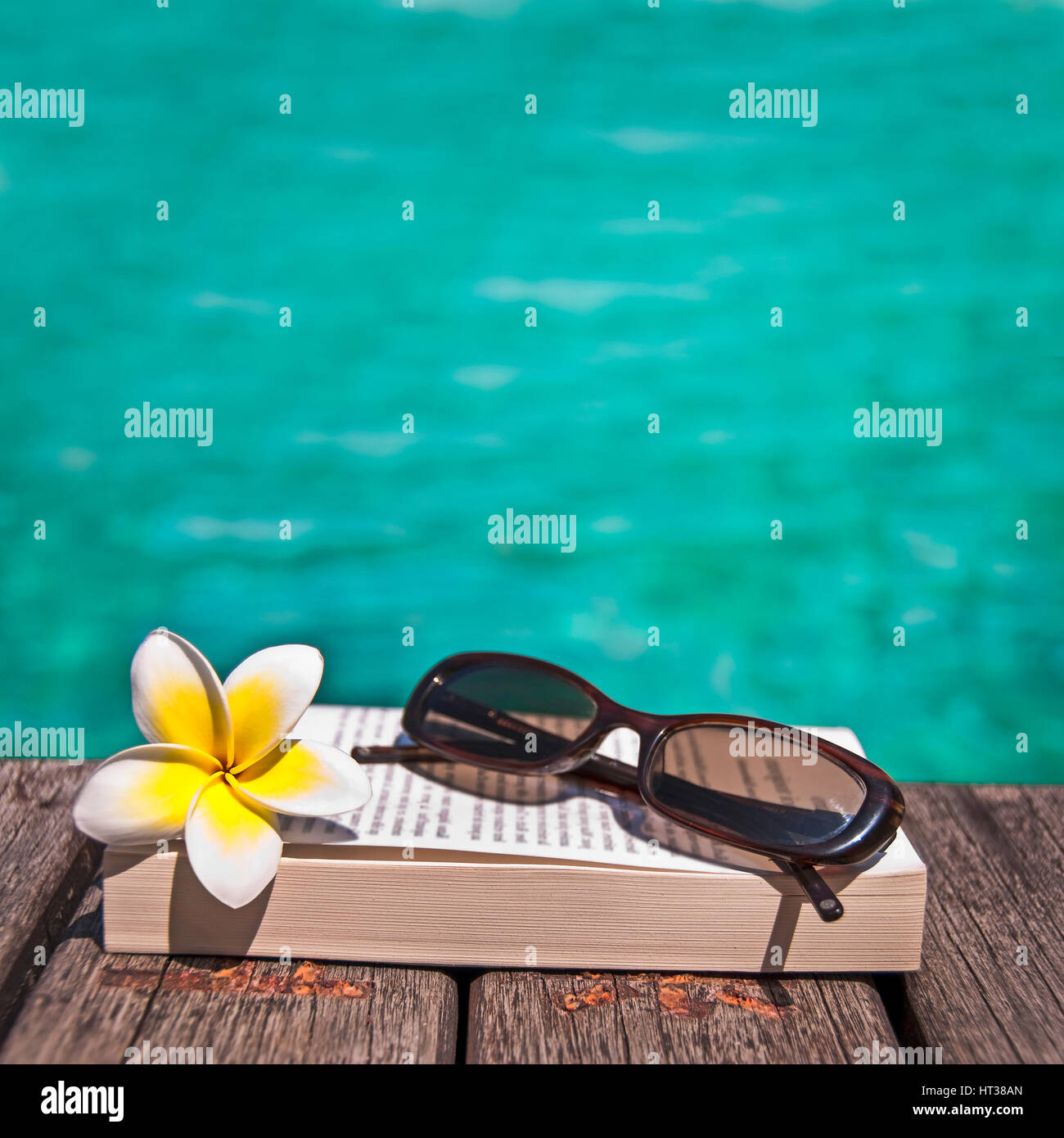 Book and sunglasses, blue water background Stock Photo - Alamy