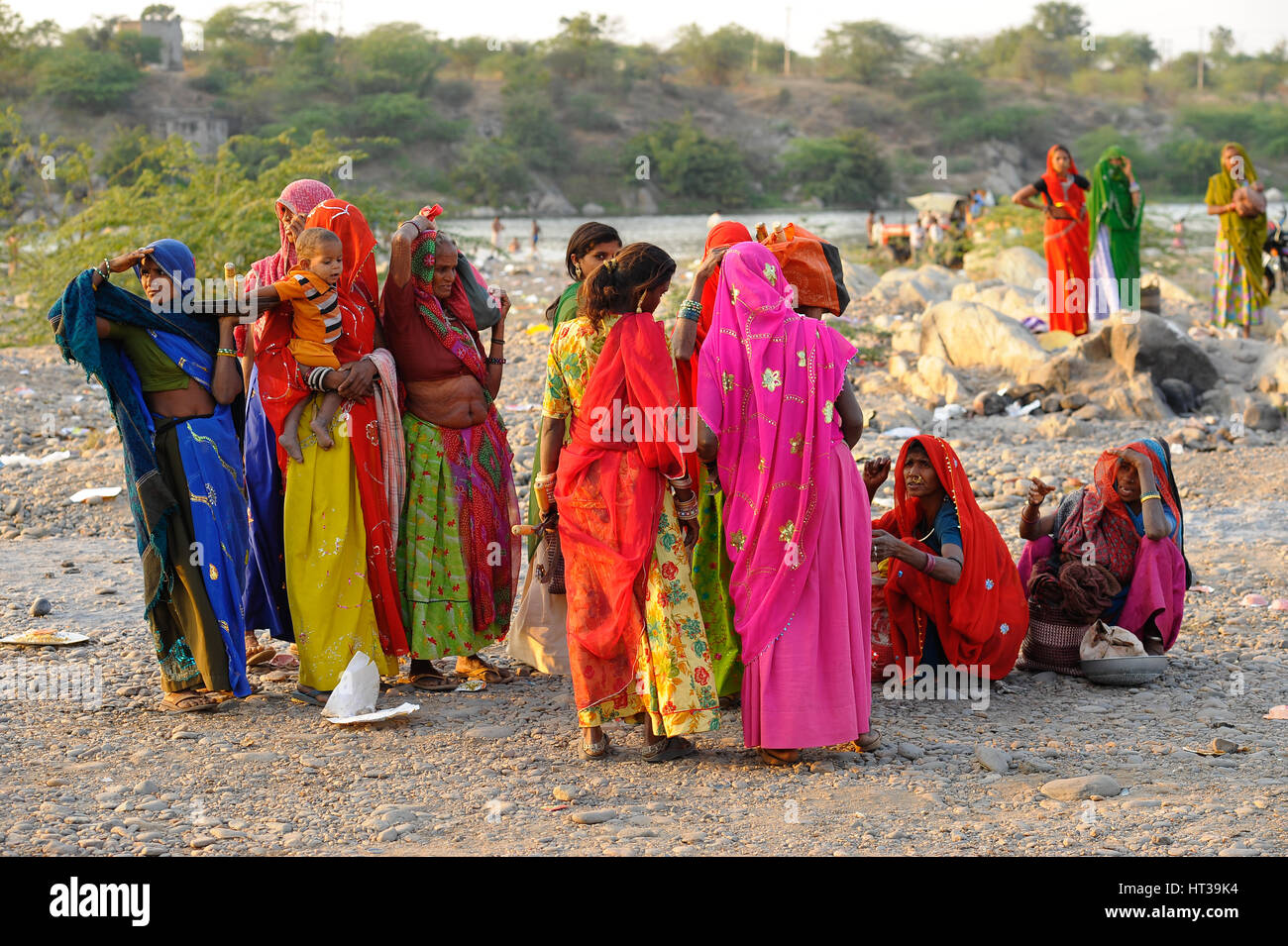 A cross-generation group of Rajasthani Bhil women, wearing brightly ...