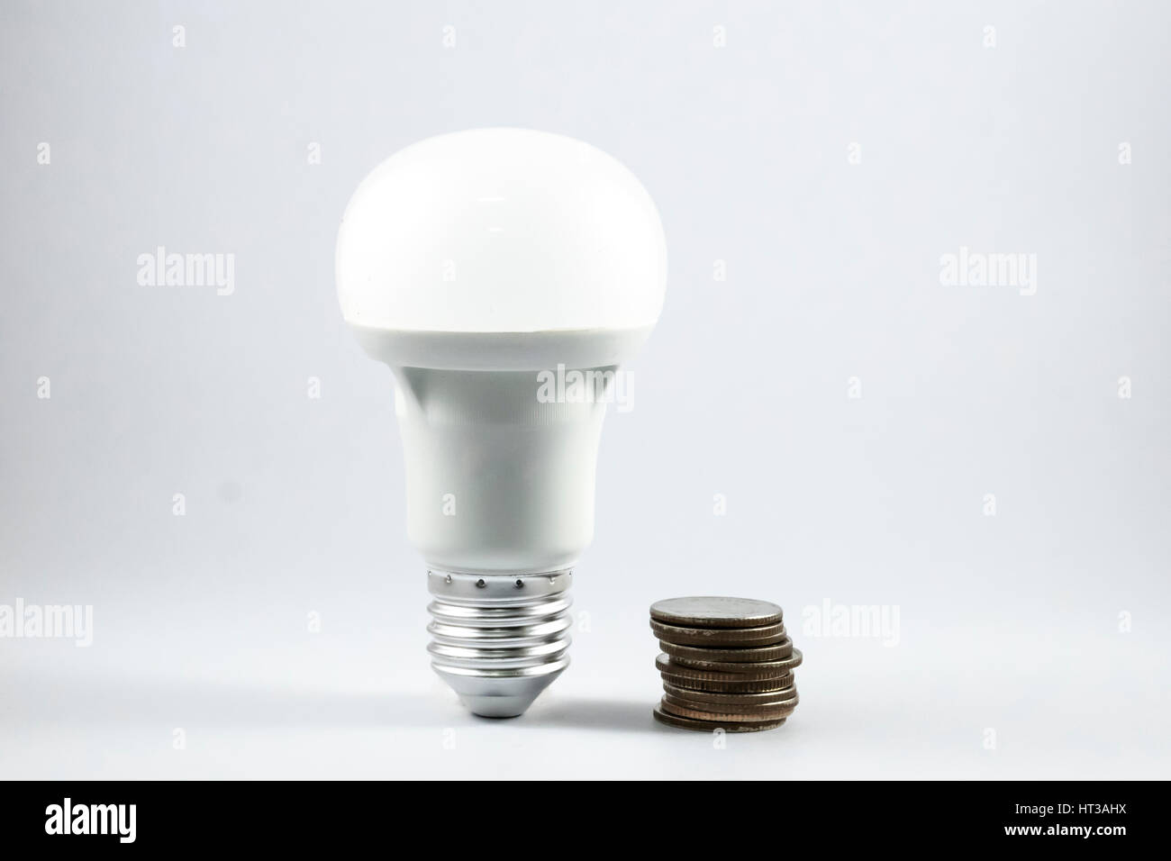 LED lamp and coin on the white background Stock Photo - Alamy