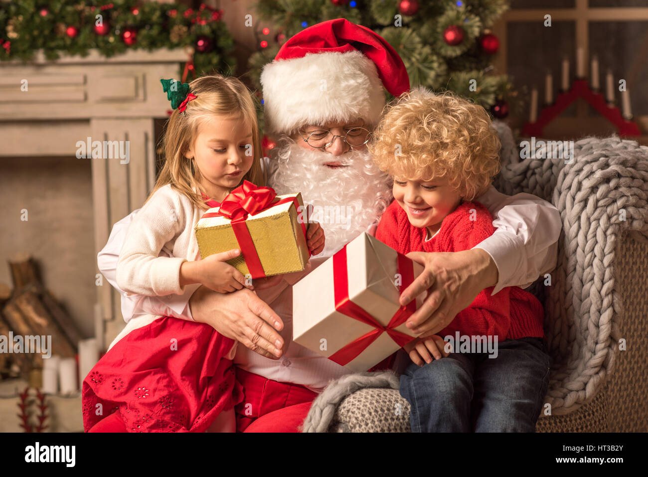 Santa Claus with children holding gift boxes Stock Photo - Alamy