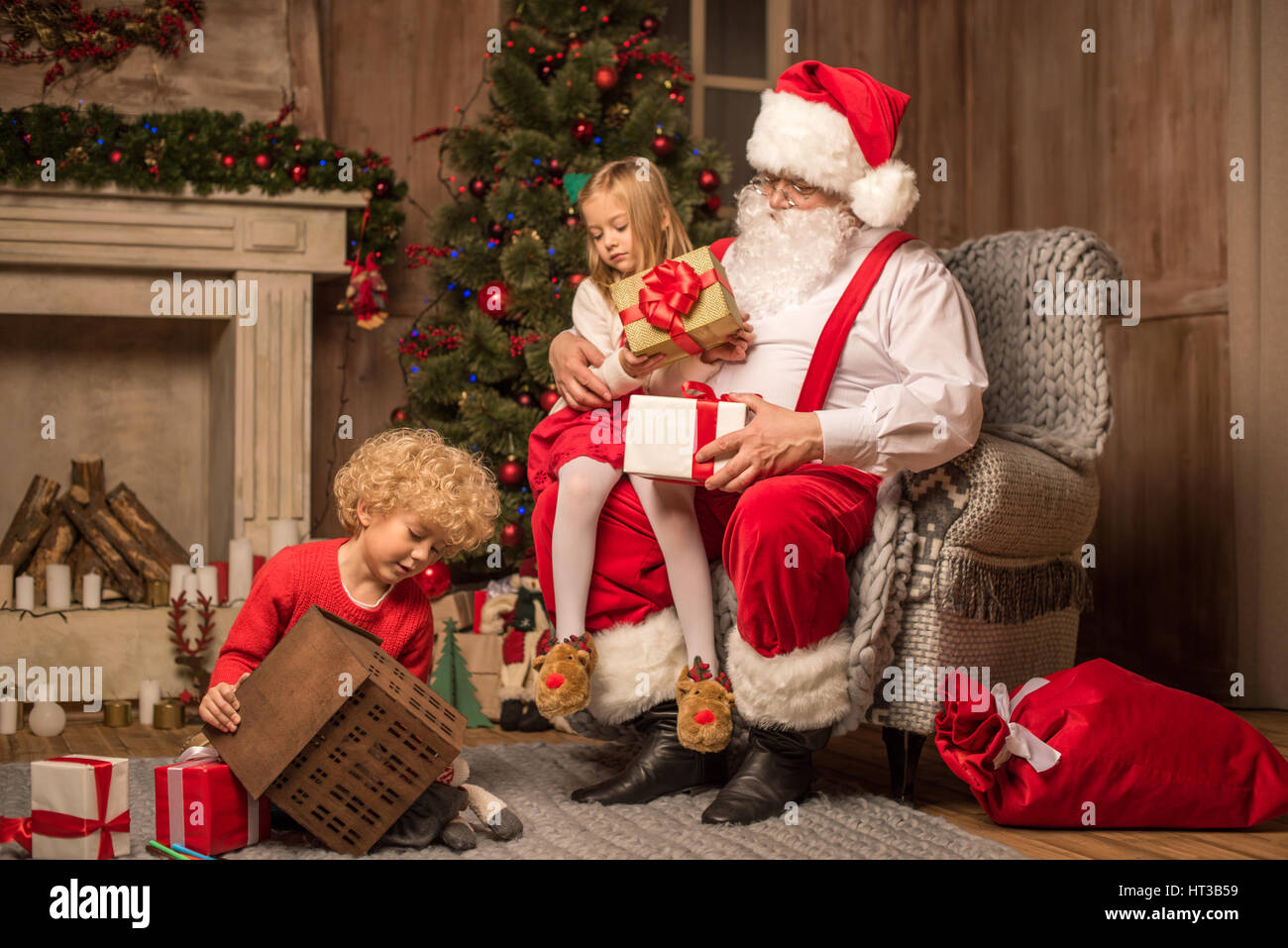 Santa Claus with children sitting near fireplace Stock Photo - Alamy