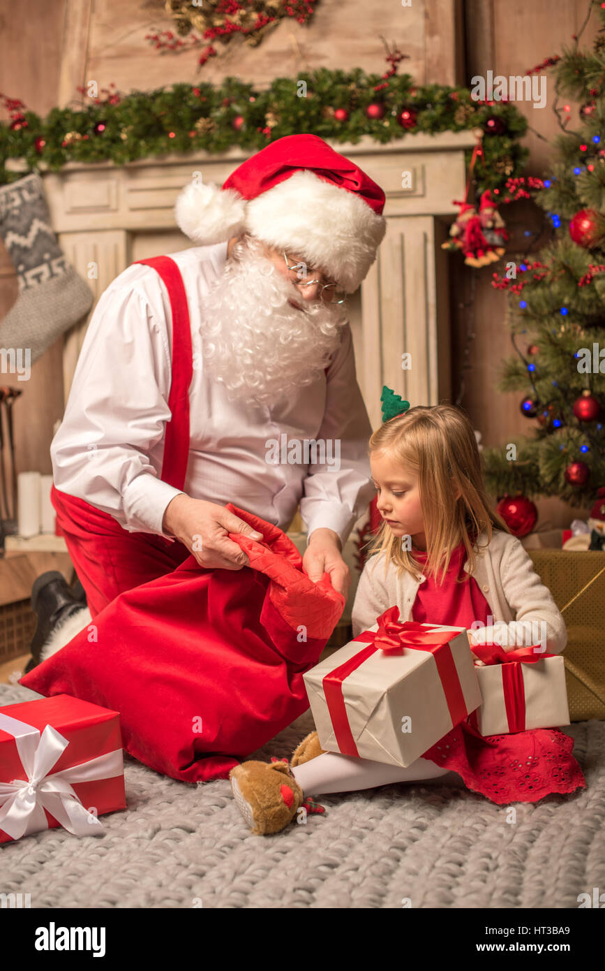 Santa Claus showing Christmas presents Stock Photo - Alamy