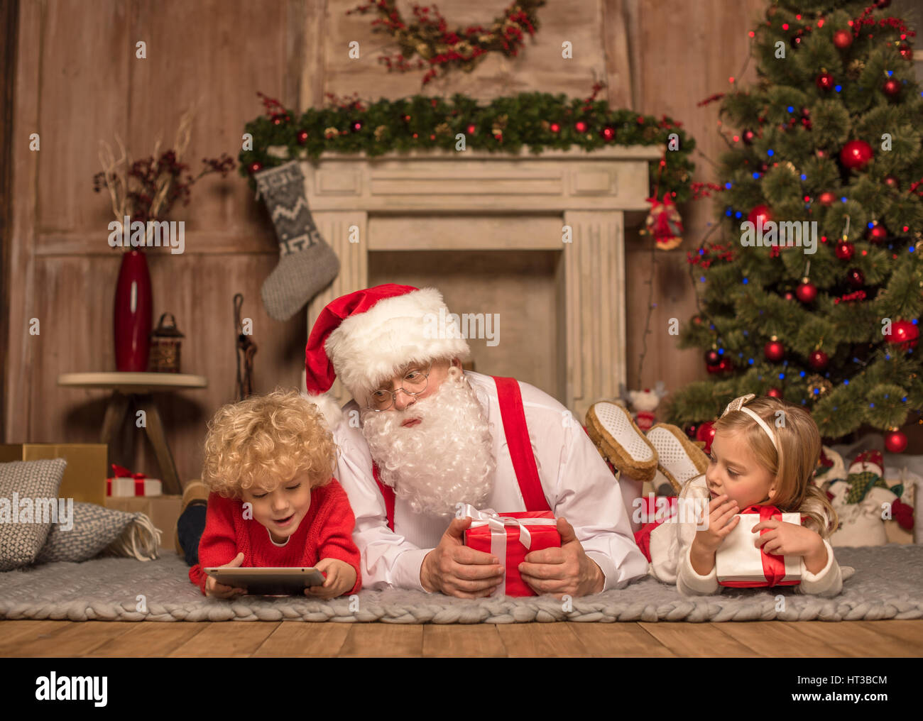 Santa Claus and children lying on carpet Stock Photo - Alamy