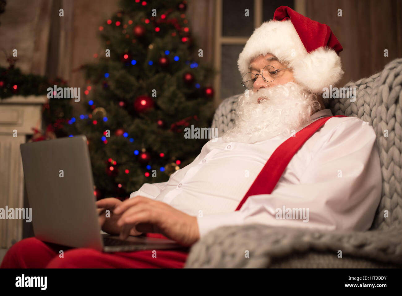 Santa Claus using laptop Stock Photo - Alamy
