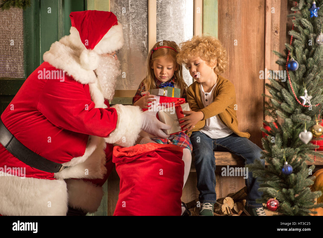 Santa Claus giving gift boxes to Children Stock Photo - Alamy